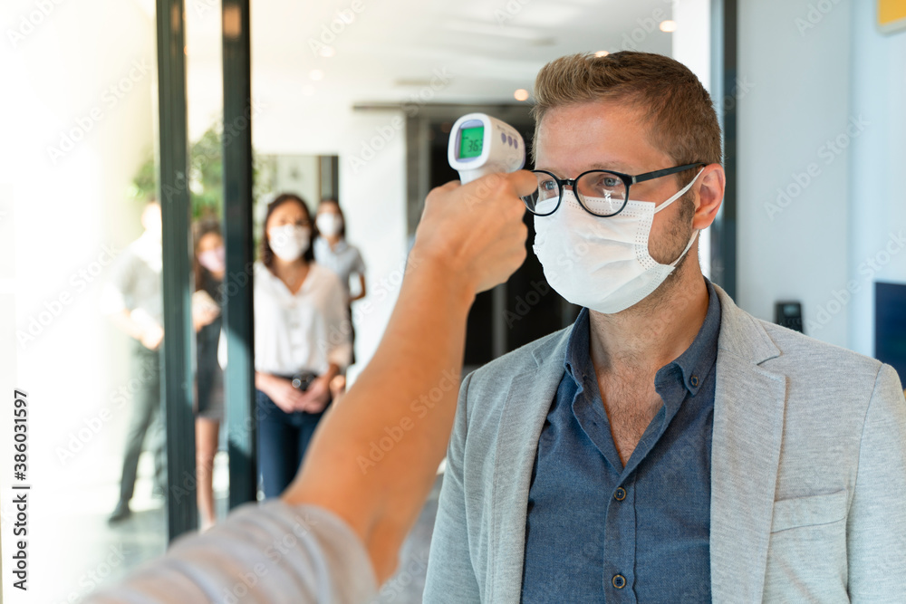 Staff check fever by digital thermometer visitor before entering the ...