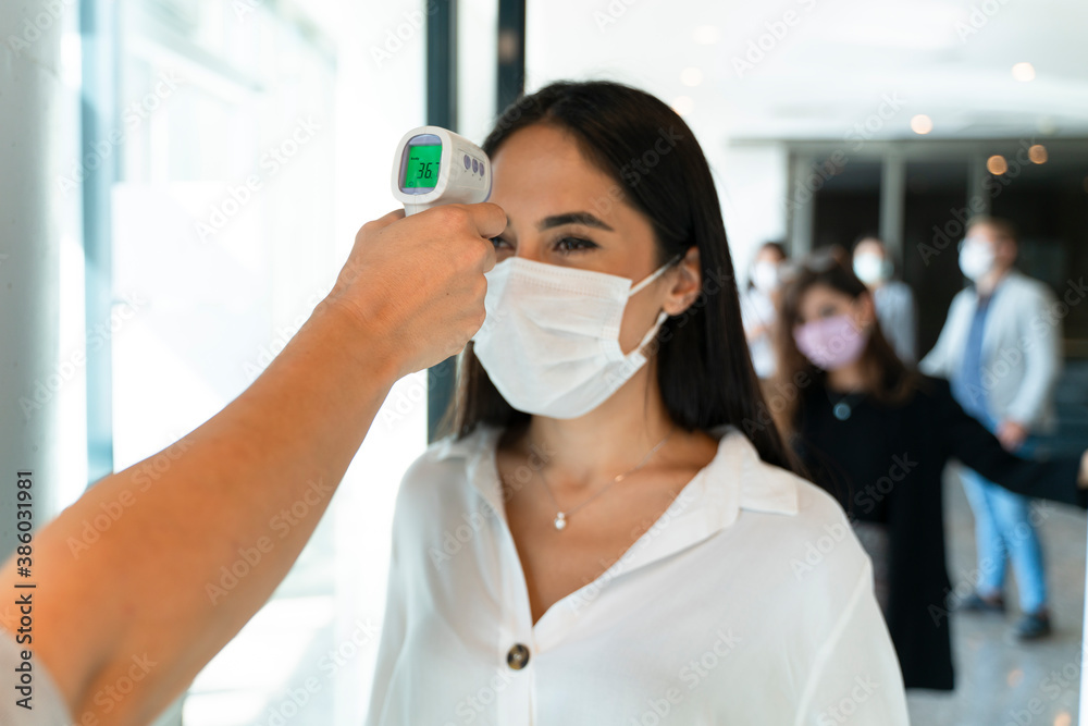 Staff check fever by digital thermometer visitor before entering the ...