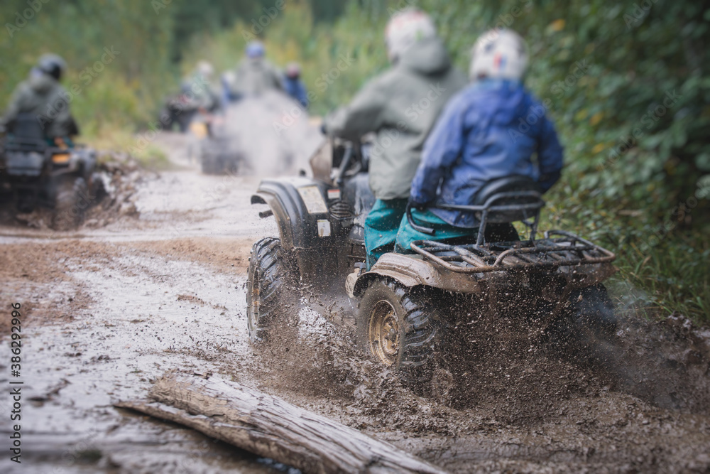 Group of riders riding atv vehicle on off road track, process of ...