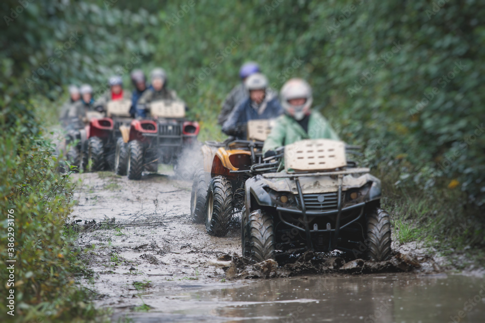 Group of riders riding atv vehicle on off road track, process of ...