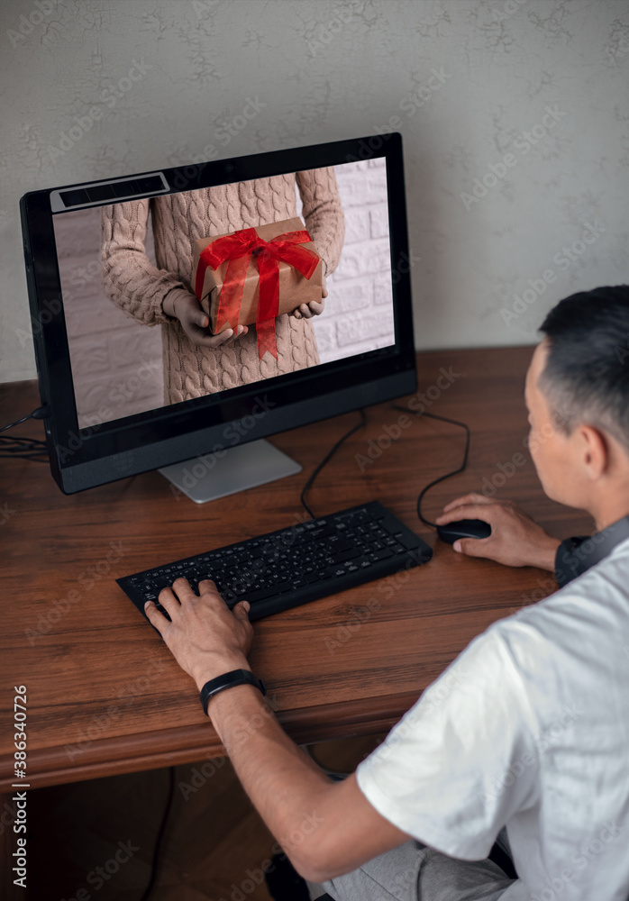 Young man sees an image on a computer screen with gloved hands holding ...