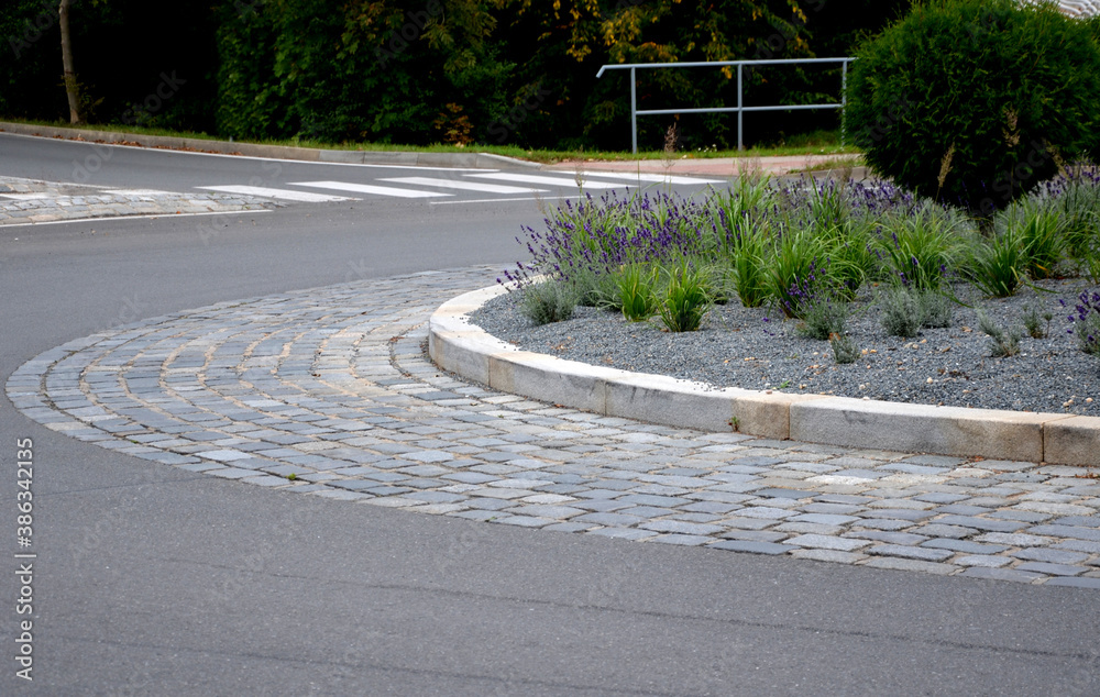 roundabout of paving gray granite cubes, transport hub, with flowers ...