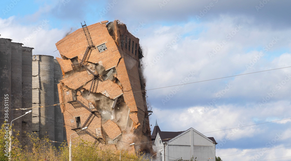 Industrial controlled explosion abandoned building on blue sky with ...