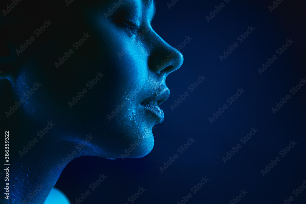 Night. Portrait of female fashion model in neon light on dark studio ...