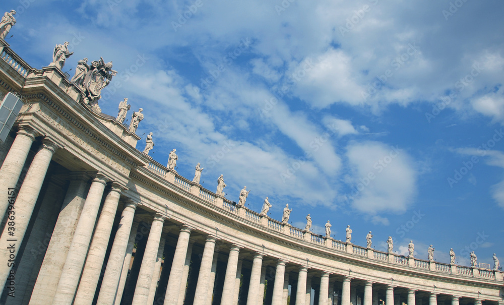 The famous colonnade of St. Peter's Square with statues in the Vatican ...