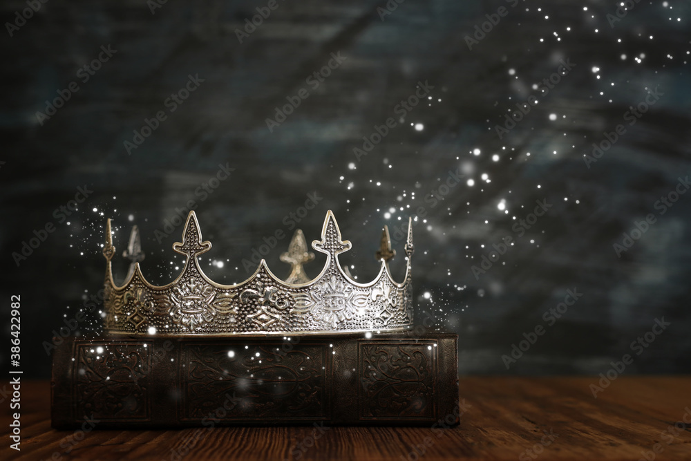 low key image of beautiful queen/king crown on old book. vintage ...