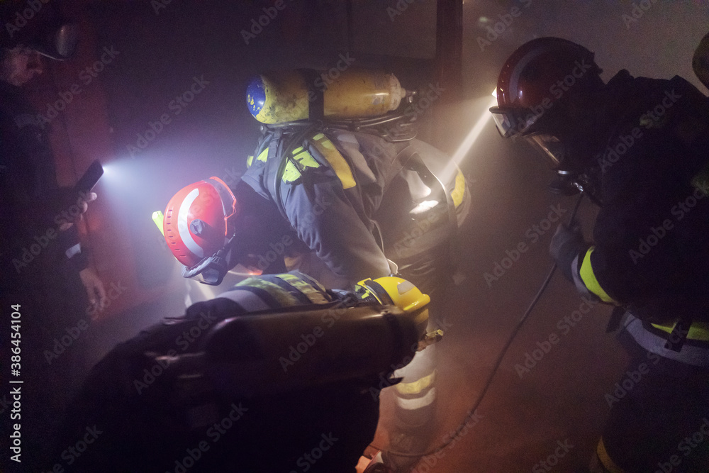 Brave firefighters releasing man from burning car. Stock Photo | Adobe ...