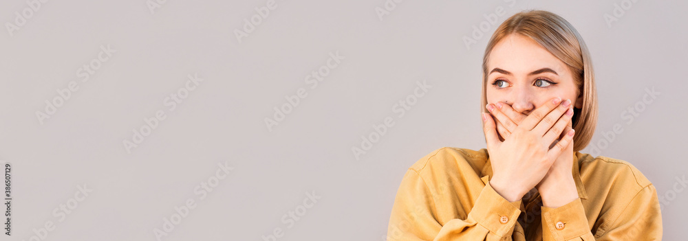 Keep silence. Scared woman covering mouth with hands while posing to ...