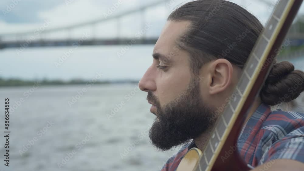 Vidéo Stock Close-up face of thoughtful artist sitting with guitar on ...