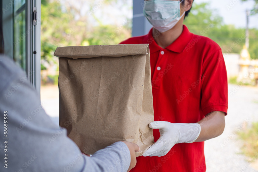 a courier wearing a red uniform with gloves and face masks to prevent ...