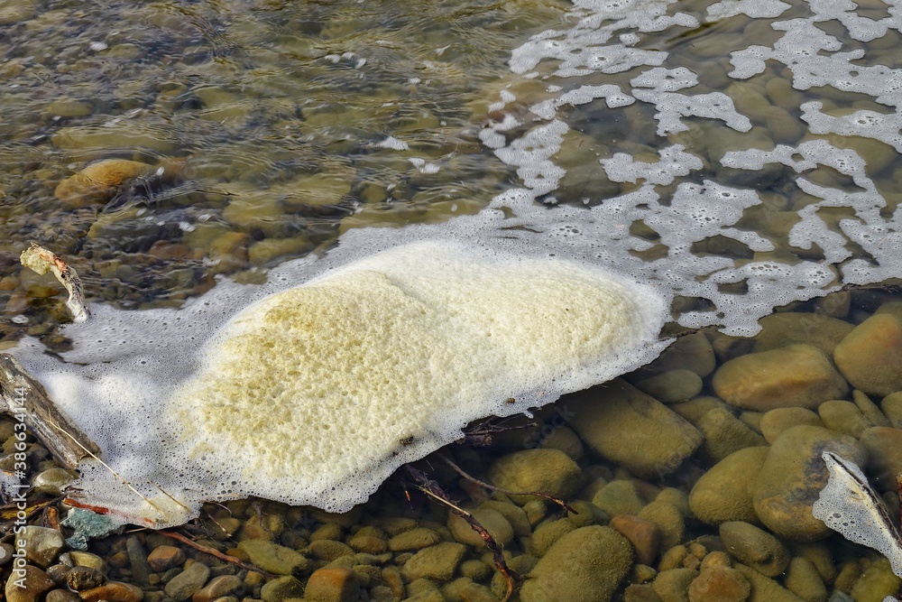 Foam flakes on the water surface of a mountain river. Environmental ...