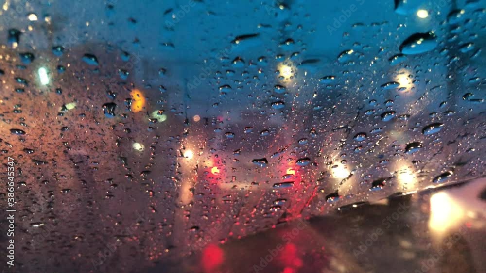 Rain falling on car windshield,colorful bokeh with street light,drive ...