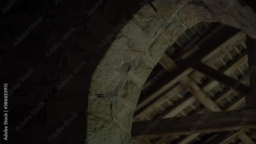 Archway entrance in old stone building with wooden roof rafters medium ...