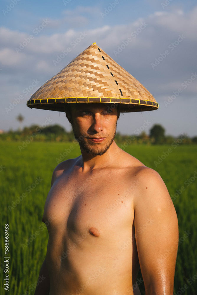 Young man with Vietnamese hat in rice fields Stock Photo | Adobe Stock
