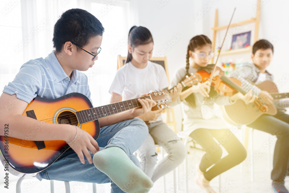 light and blur people, asian children sitting and playing guitar, asian ...