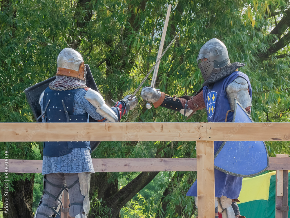 Foto de Two foot warriors in heavy medieval armor fight in the arena ...
