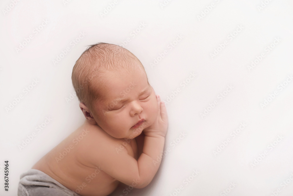 newborn photoshoot of a small newborn baby sleeps on his tummy ...