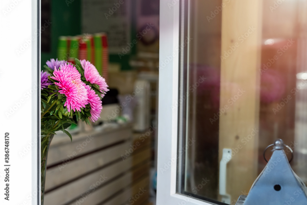 Open window with pink daisy flowers in vase of street city urban cafe ...
