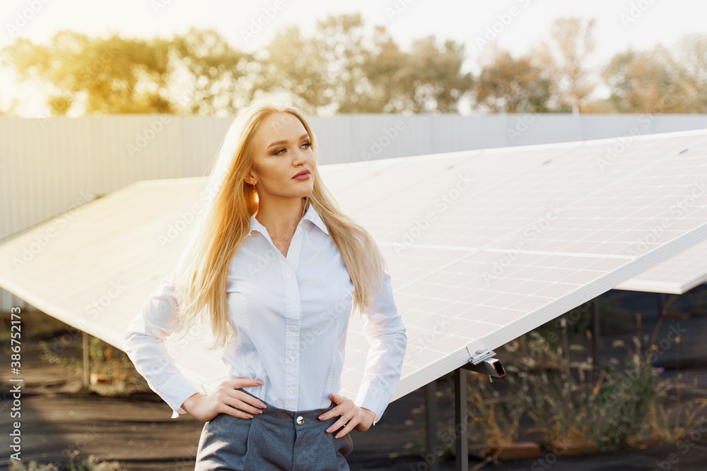 Girl stand and look right side near solar panels row on the ground with ...