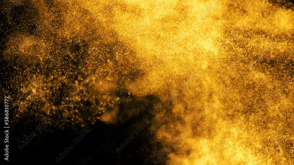 Gold dust particles fly in slow motion in the air lingering slowly ...