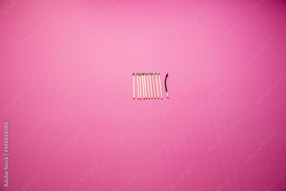Burnt matches and whole matches on PINK background. The spread of fire ...