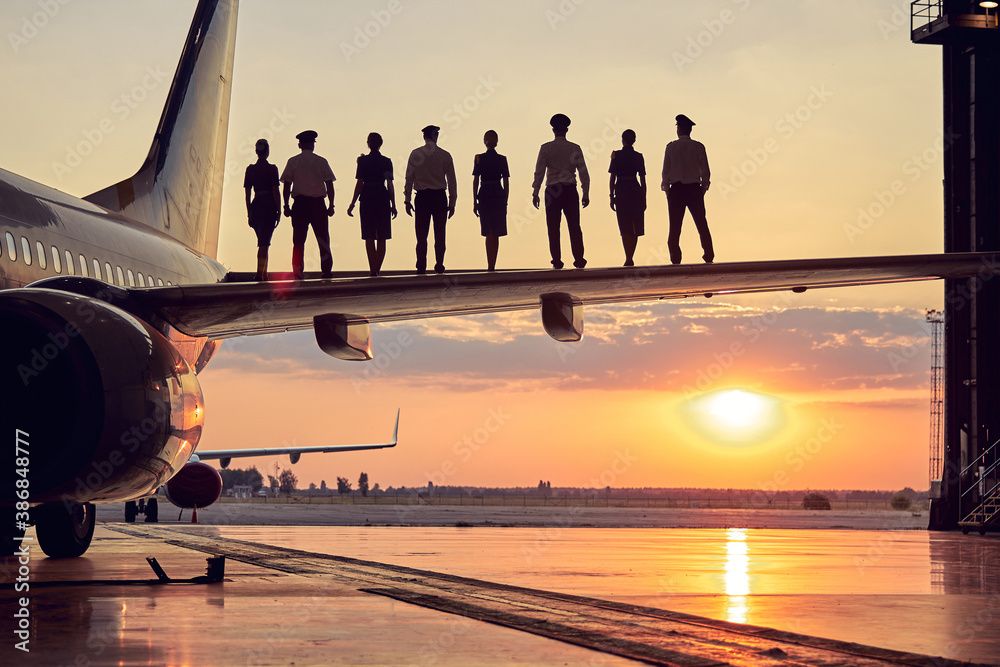 View of people looking to the beautiful sunset in the aviation hangar ...