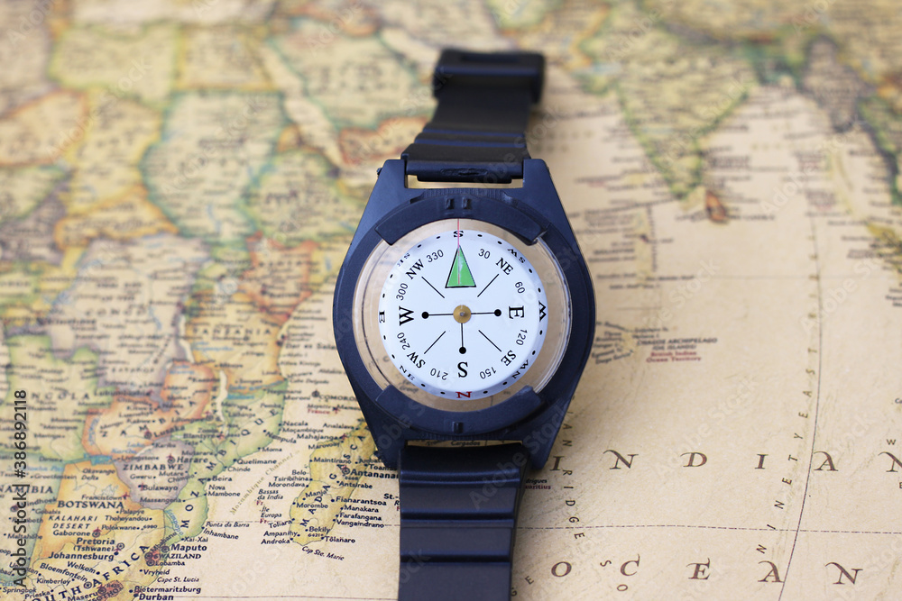 Classic round compass on background of old vintage map of world as ...