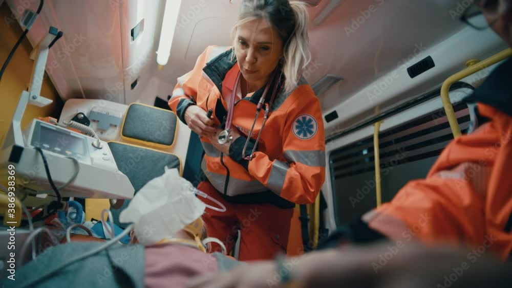 Female and Male EMS Paramedics Provide Medical Help to an Injured ...