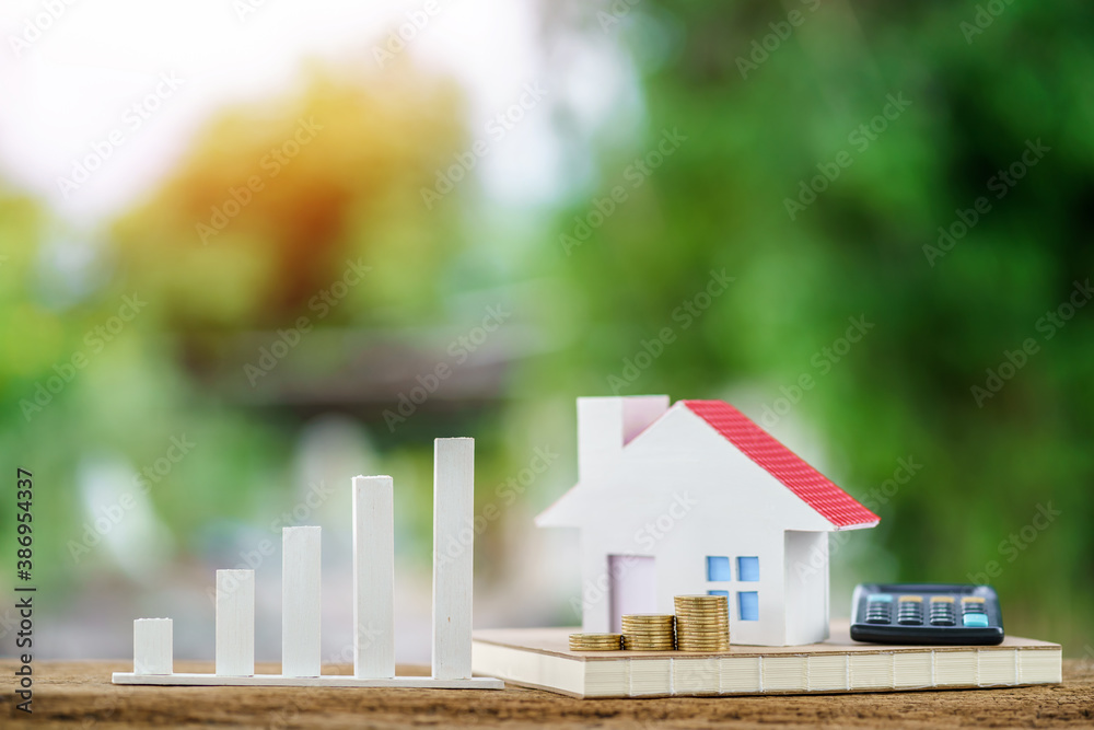House model and bar graph with growing value and calculator put on the ...