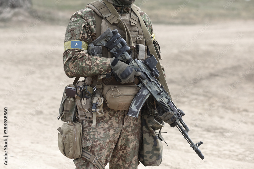 Soldier with machine gun and flag of Somalia on military uniform ...