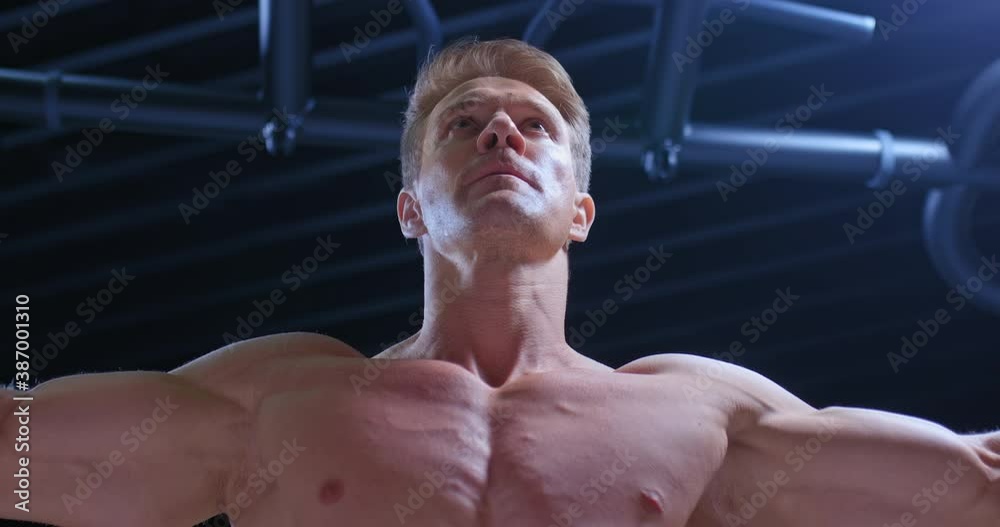 Portrait of a young muscular bodybuilder doing convergence of hands on ...