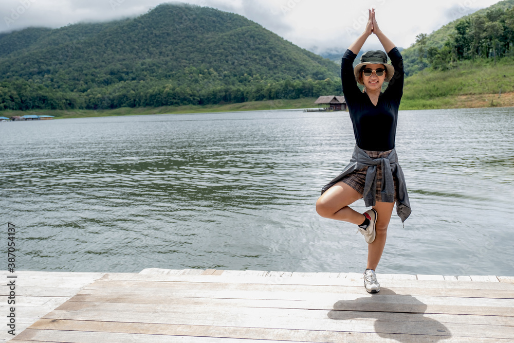 Beautiful young Asian tourists doing stretching exercises with yoka ...