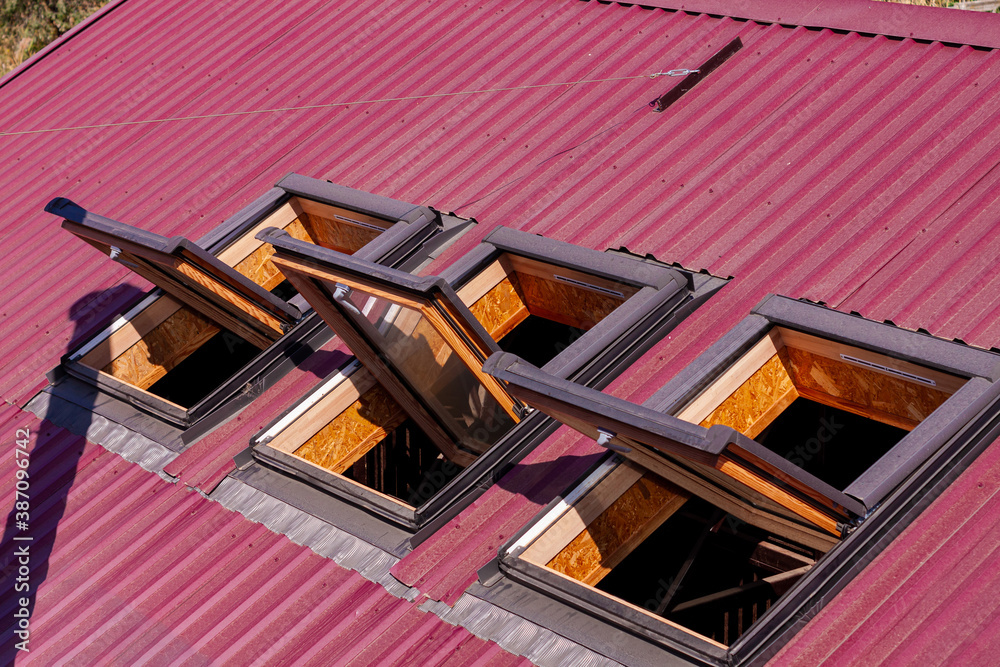 Opened roof windows. Skylight on red ceramic house tiles. Skylights ...