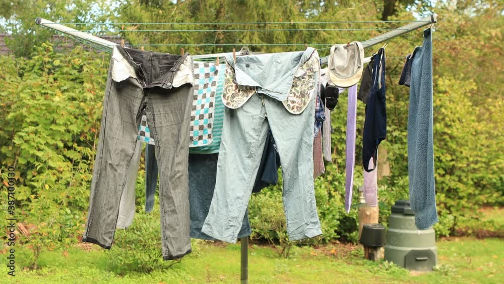 Laundry gently waving in a breeze hanging to dry in a garden on a ...