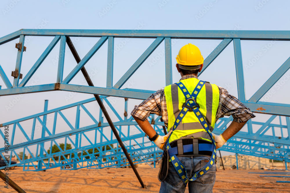 The back of construction worker wearing safety harness and safety line ...
