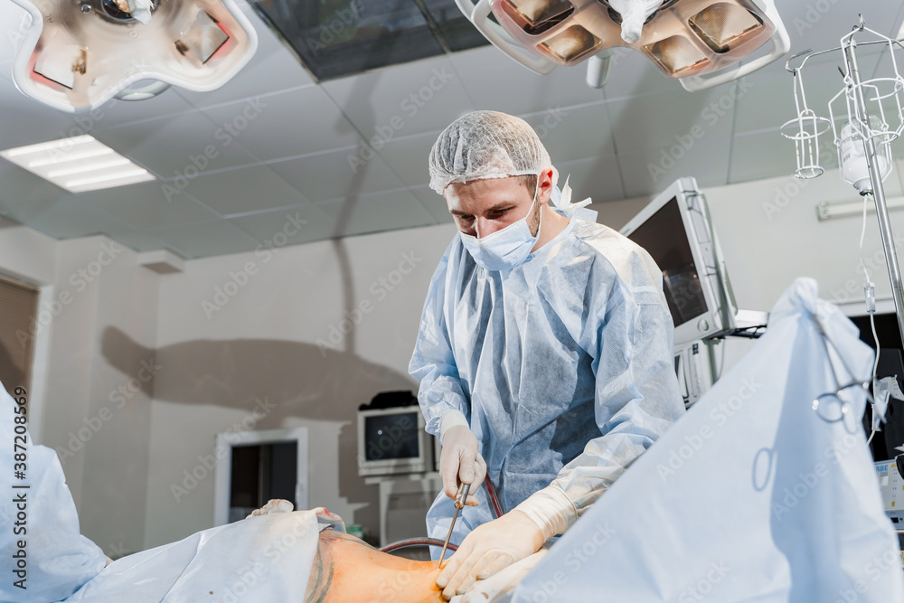 Surgeon removes fat in the gluteal region. Abdominoplasty - plastic ...