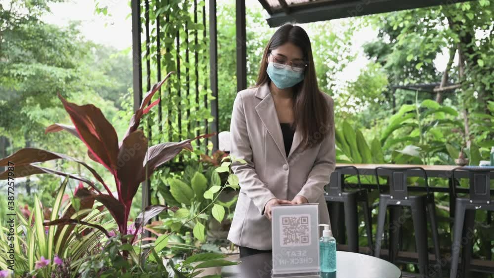 Asian female scan check-in QR code by smartphone app and cleansing hand ...