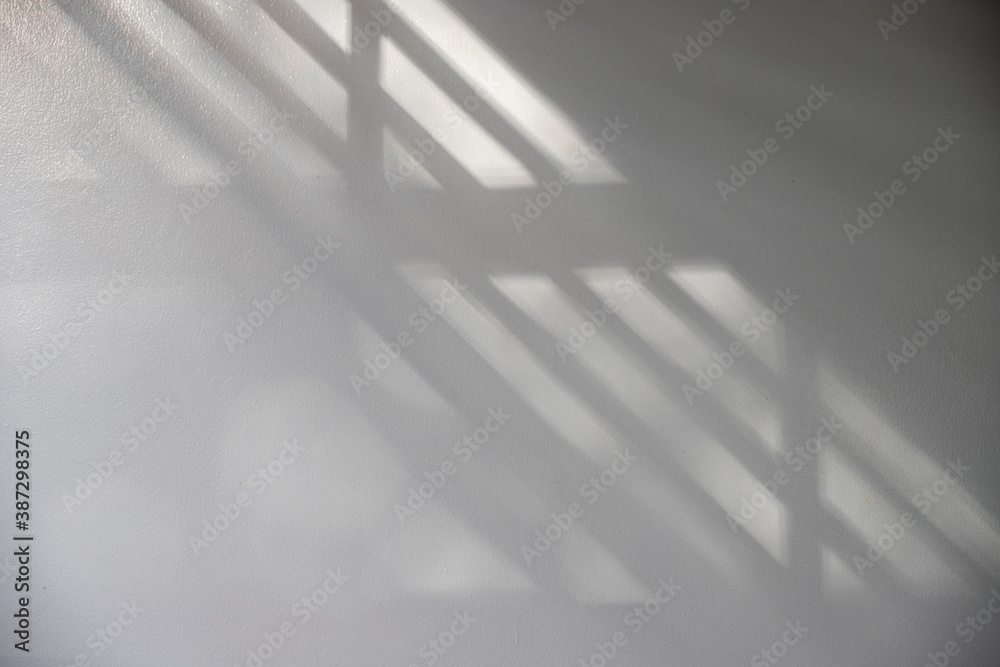 abstract shadow batten of lath and morning light on white concrete wall ...