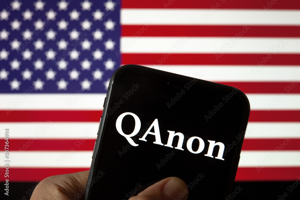 QAnon organisation logo seen on the smartphone which is placed on USA ...