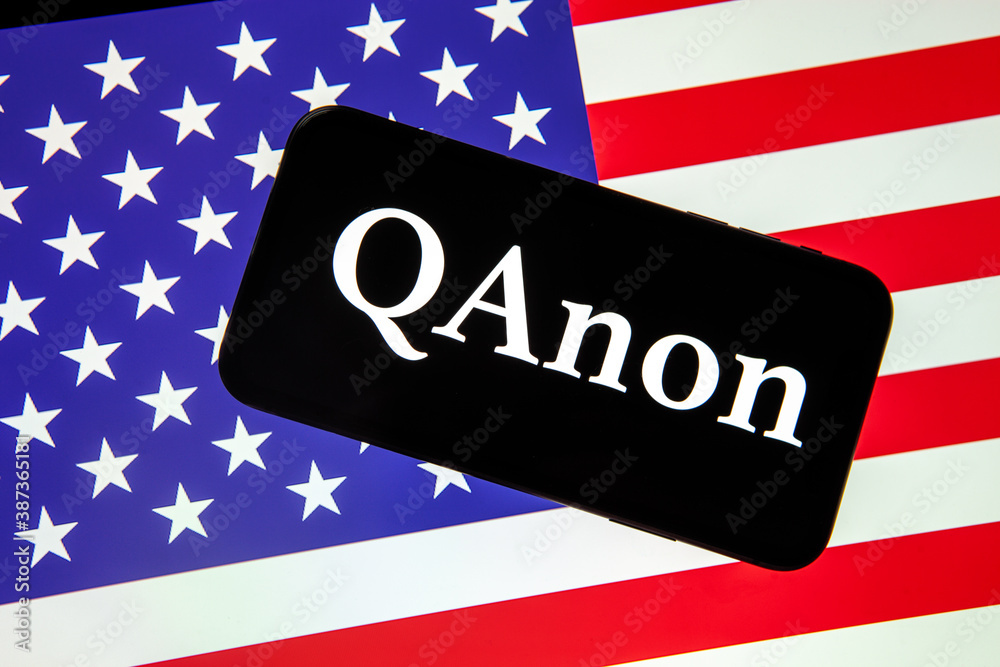 QAnon organisation logo seen on the smartphone which is placed on USA ...