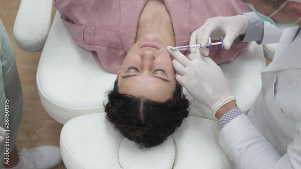 Young woman getting beauty facial injections in salon. Beautician makes ...