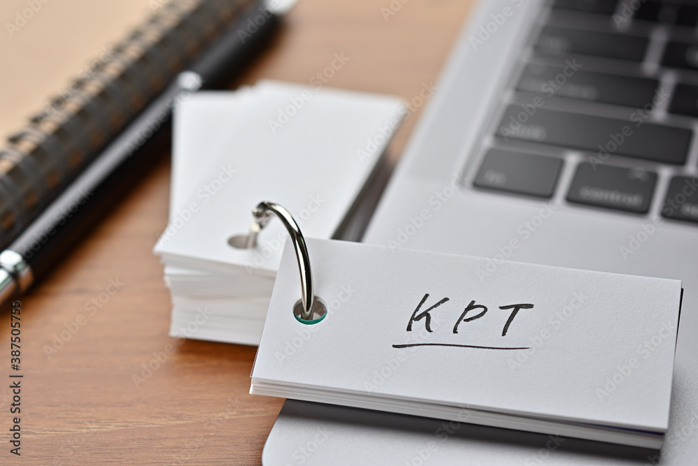 The words "KPT" written in a word book with laptop PC and a pen. It is ...