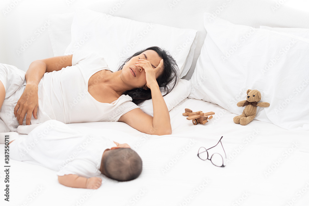 Being mom is so exhausted. Tired mother laid in bed with newborn baby ...