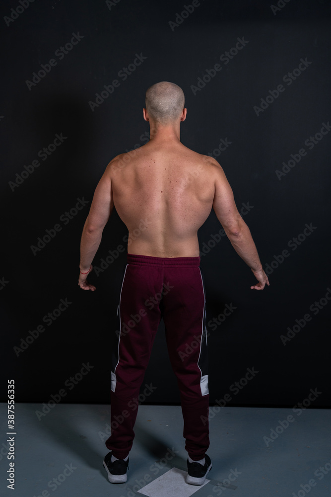 A sports guy of beautiful strength builds muscles in training. Strong ...