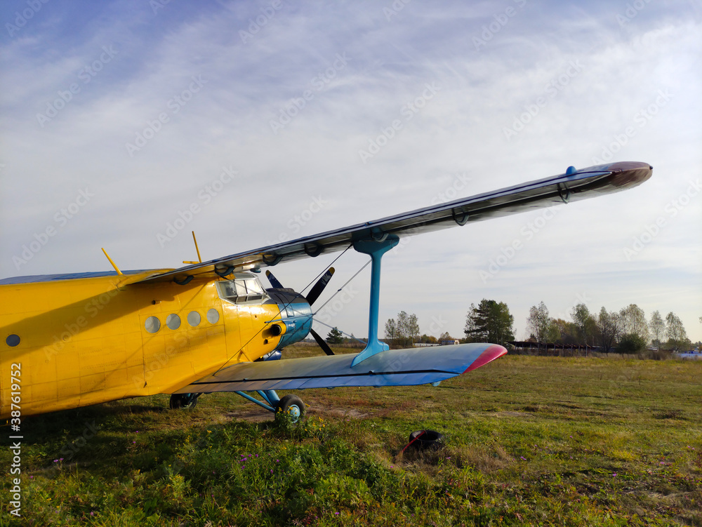 Yellow and blue old biplane plane with a single piston engine and ...