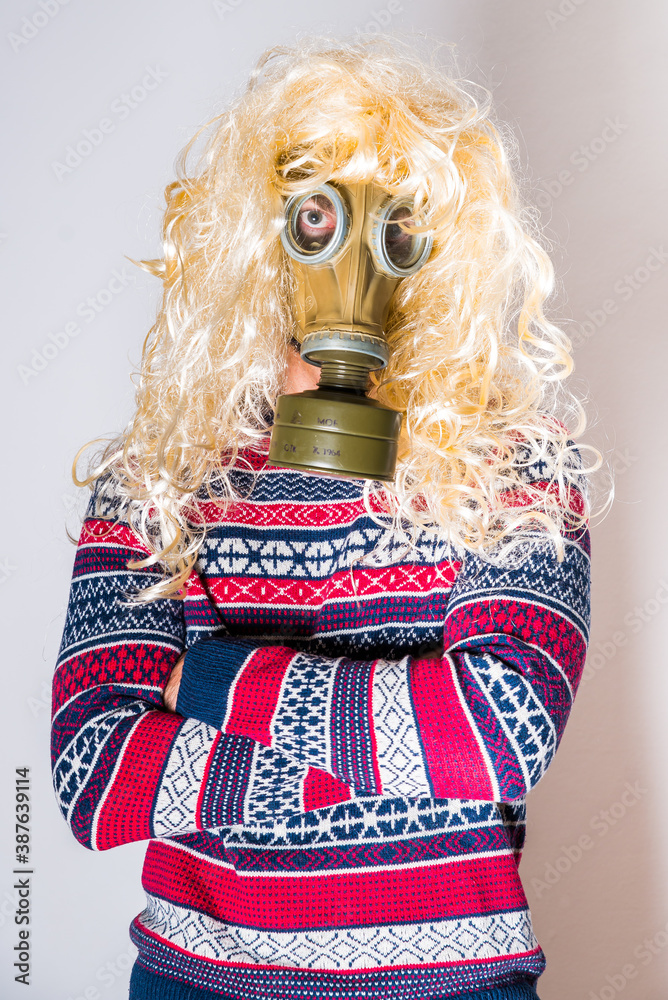 Angry trans person with cross arms and long curly hair in gas mask face ...