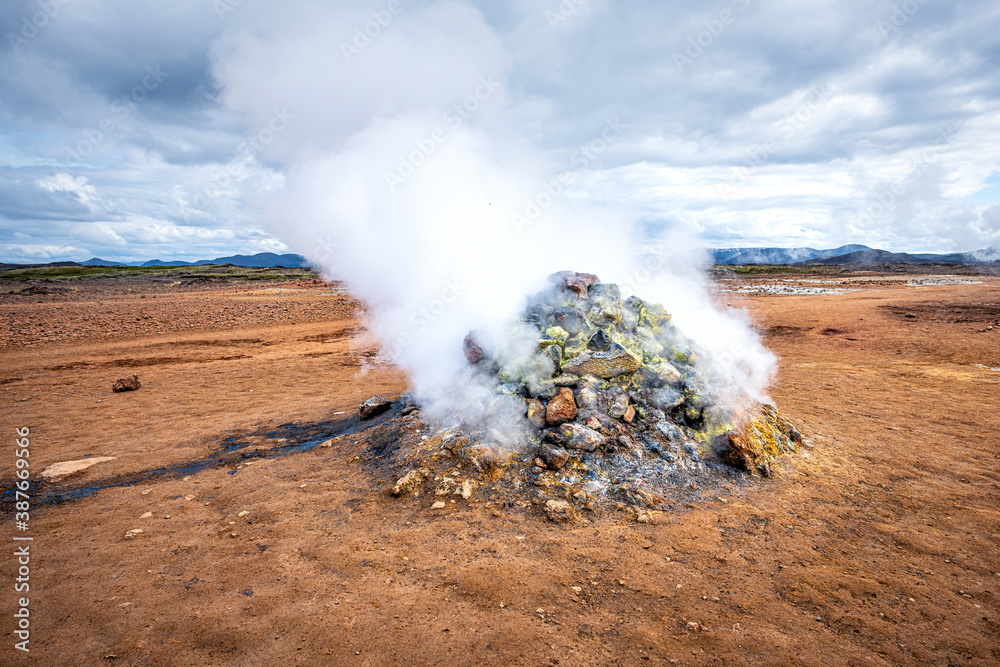 Hot steam rising from pile of rocks geyser in Hverir geothermal spot ...