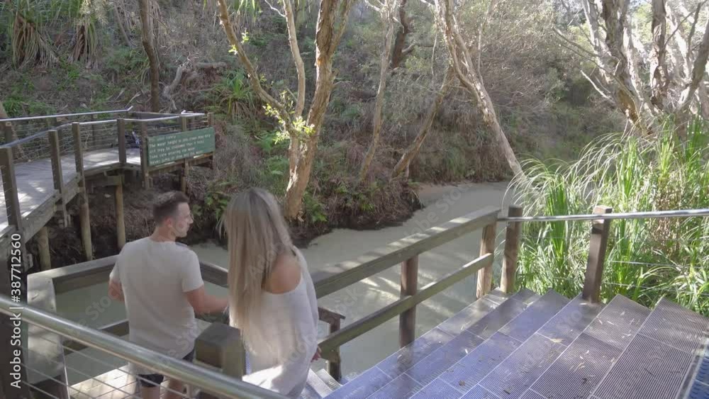 Young Couple walking down steps and wading in water at Eli Creek ...