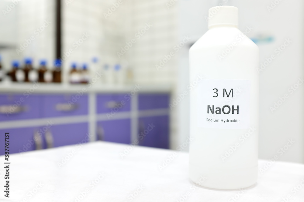 Selective focus of a plastic bottle of sodium hydroxide solution or ...