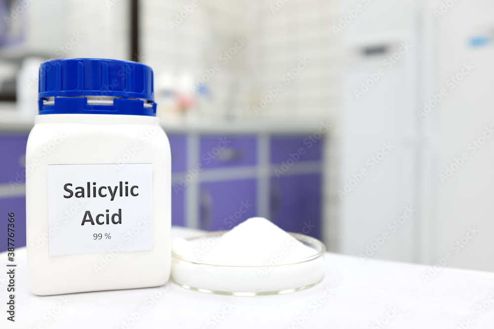 Selective focus of pure salicylic acid chemical compound beside a petri ...